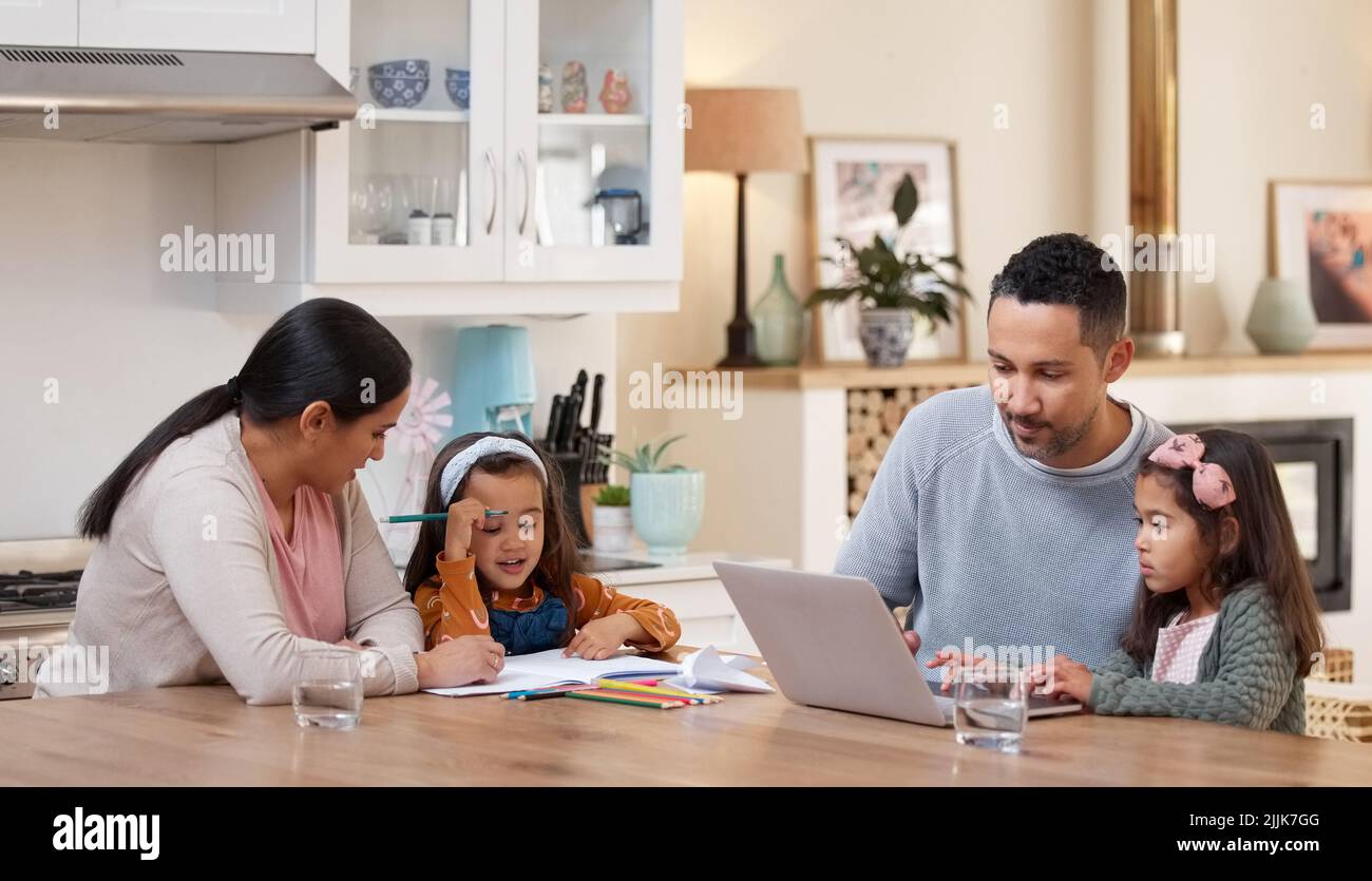 Dont worry well help you. two parents helping their children with their homework Stock Photo - Alamy