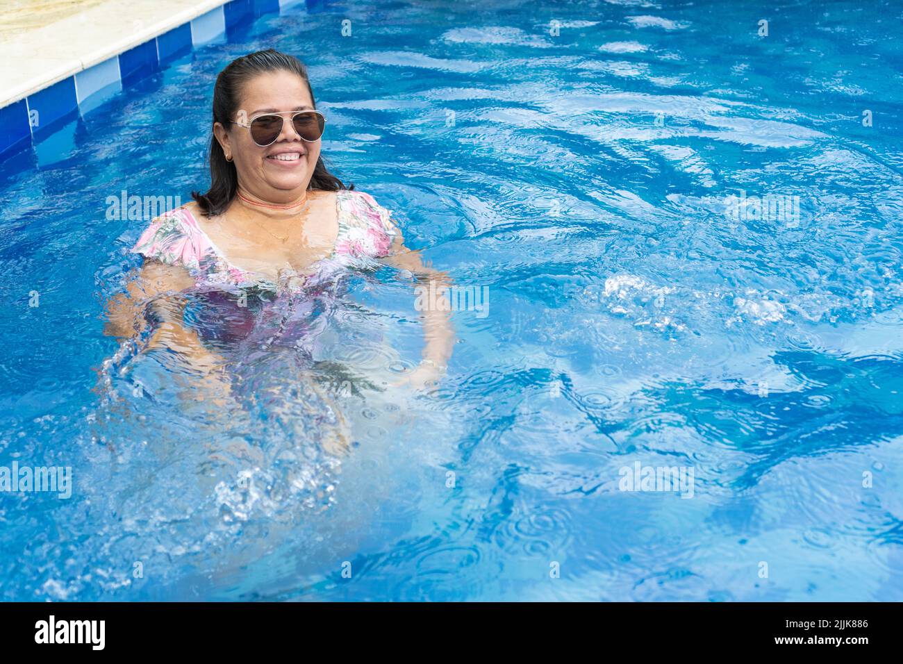Senior woman relaxing in swimming pool Stock Photo - Alamy