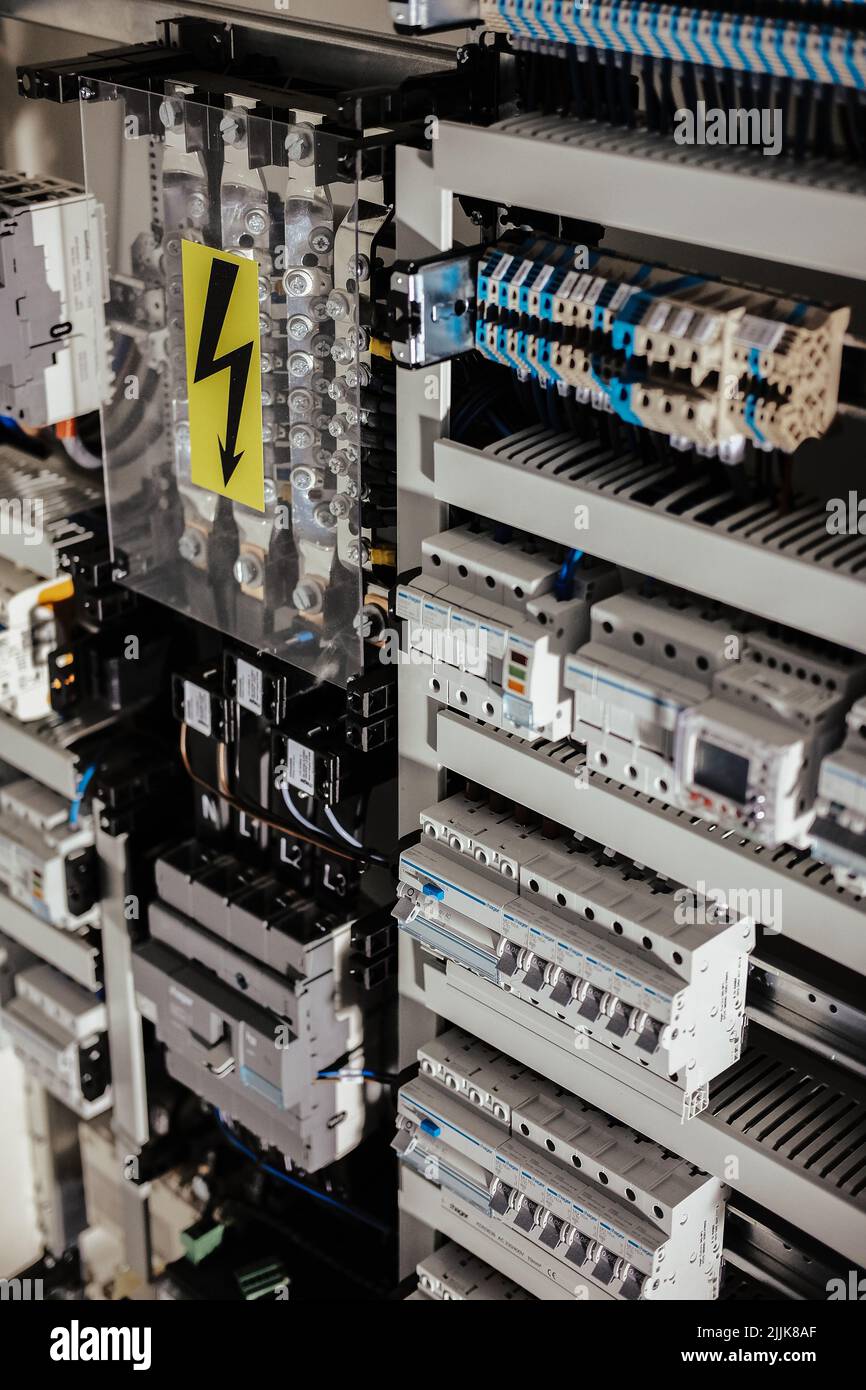 A vertical shot of cords and wiring with a warning shock sign Stock ...