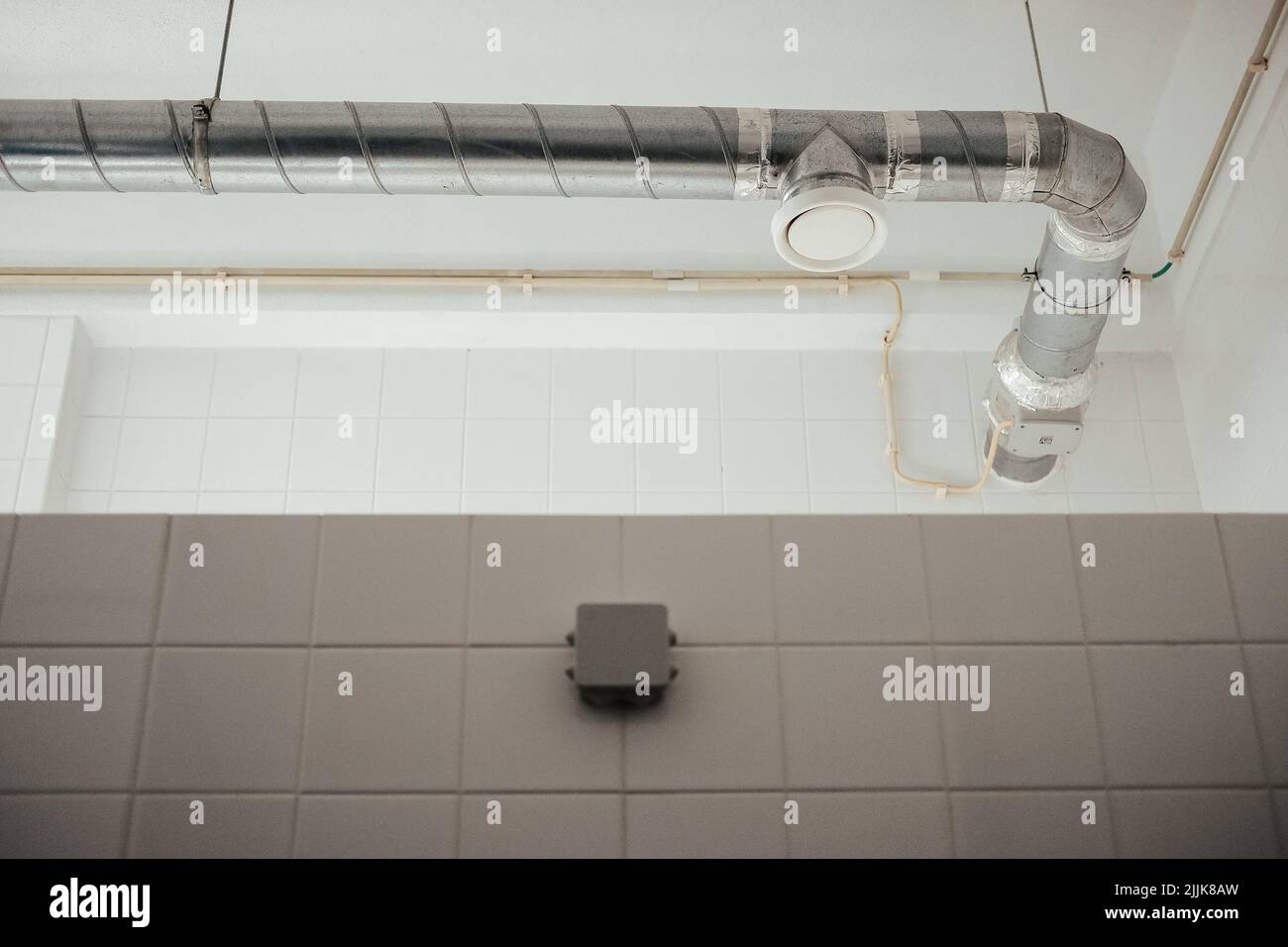 A low angle shot of a silver pipe over a bathroom stall Stock Photo - Alamy