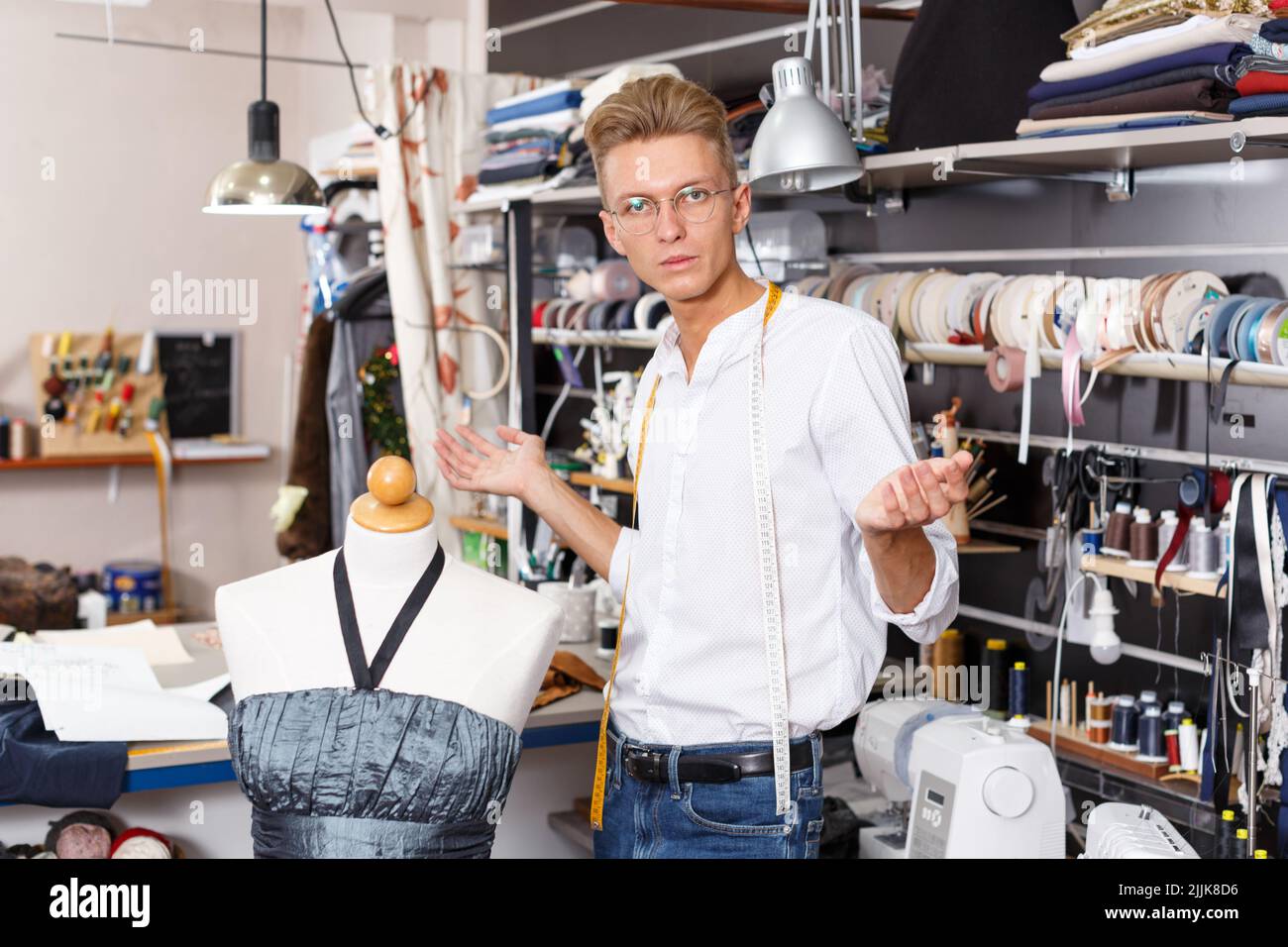 Confused tailor standing near mannequin Stock Photo - Alamy
