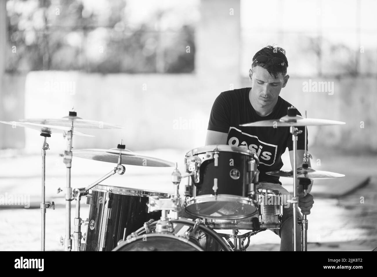 A grayscale of a young Bosnian male drummer playing the drums and ...