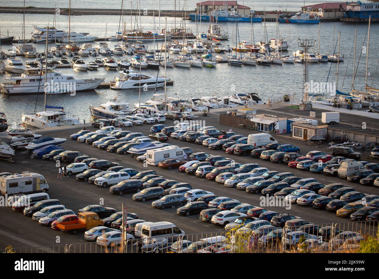 A beautiful shot of a harbor full of boats and a parking full of cars ...