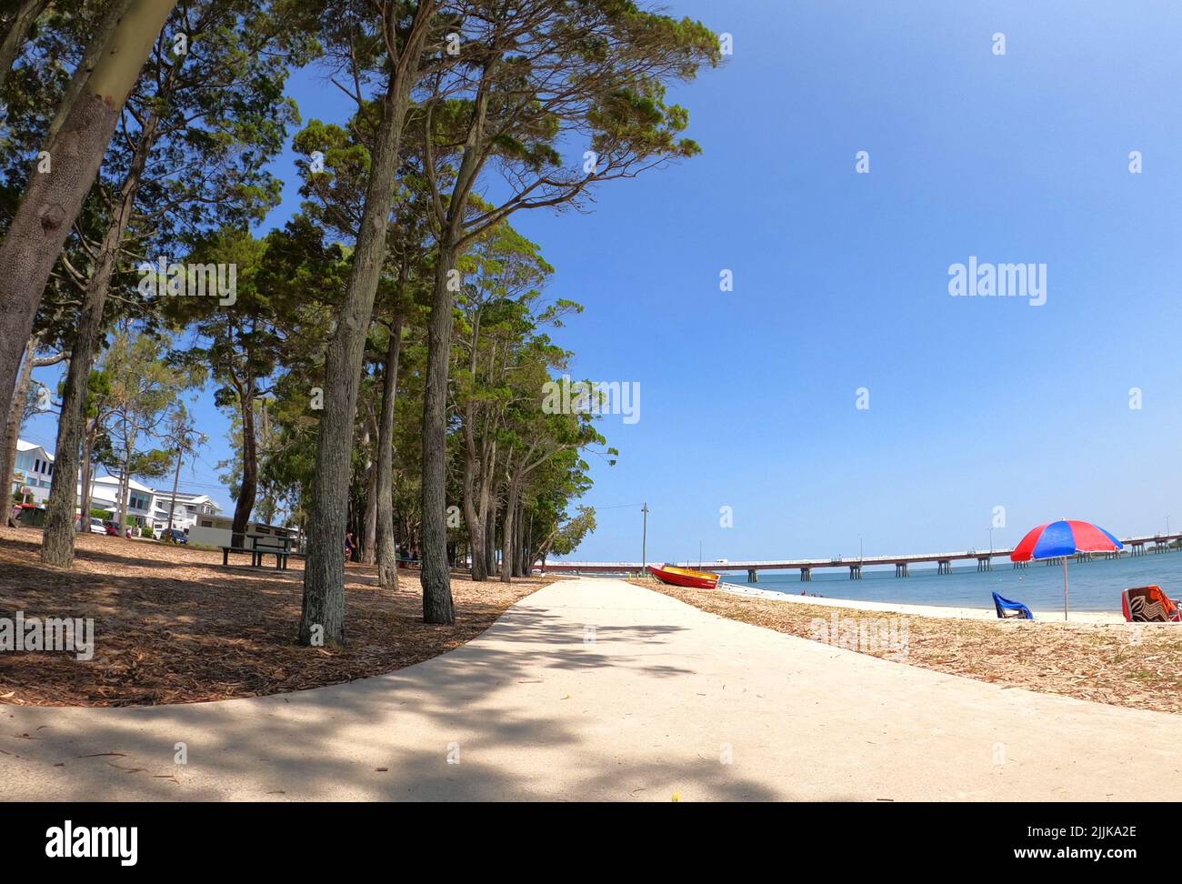 A sunny scene with a waterside walkway and Bribie Island Bridge ...