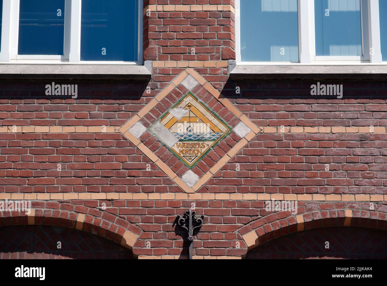 On the facade of a brick building, geodetic wall tile with the dutch ...