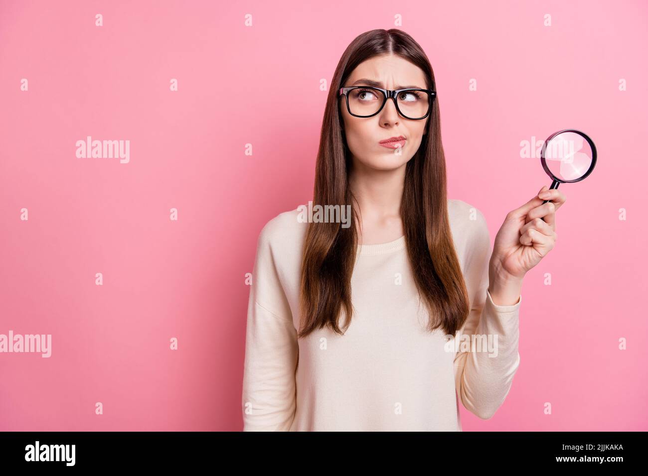 Portrait of attractive suspicious girl using loupe copy space ad ...
