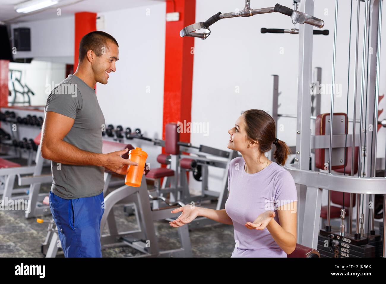 Trainer and woman having conversation at gym Stock Photo - Alamy