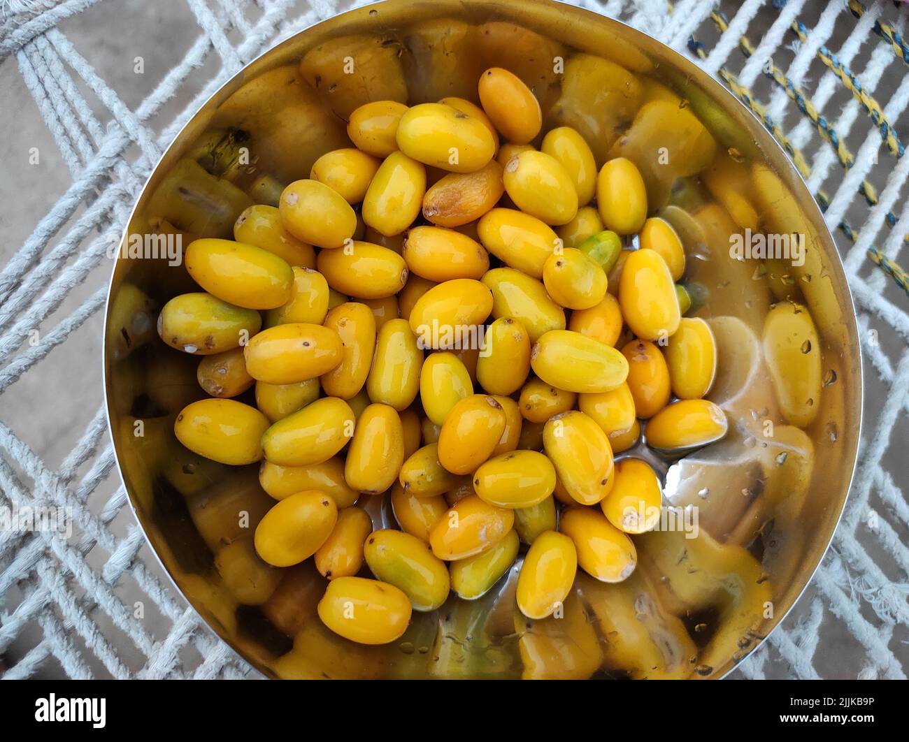 A view of Manilkara Hexandra yellow fruits in a steel bowl Stock Photo ...