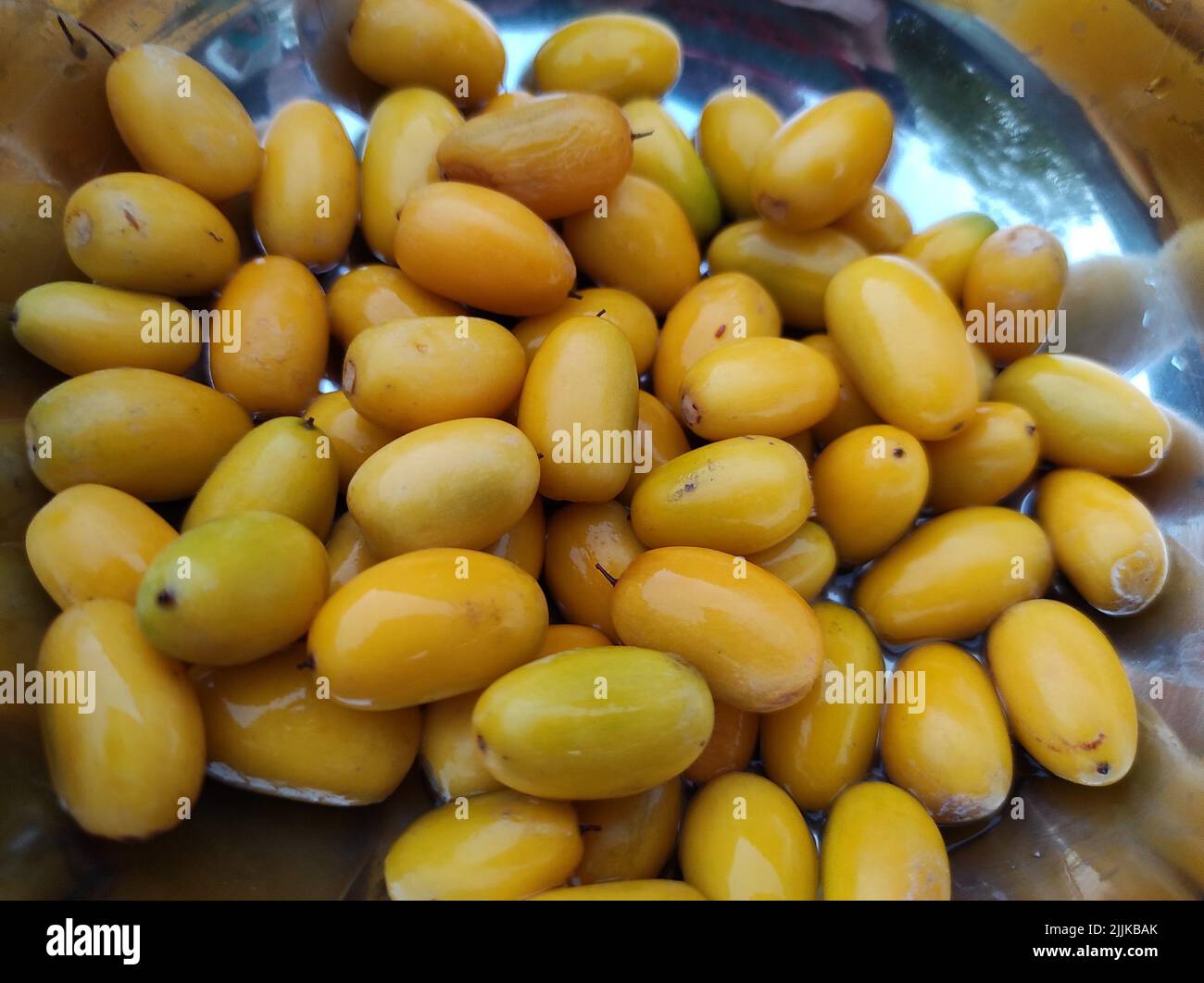 A view of Manilkara Hexandra yellow fruits in a steel bowl Stock Photo ...