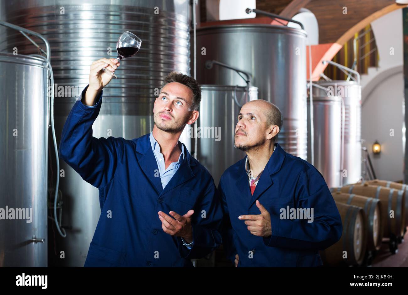 two workers on wine factory Stock Photo - Alamy
