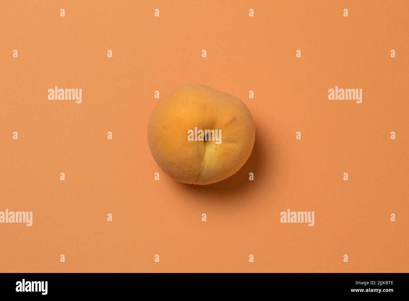 A top view of a fresh peach isolated in the orange background Stock ...