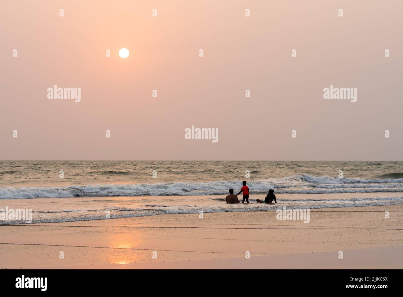 A family sunbathing and relaxing at Ashwem Beach in Goa, India Stock ...