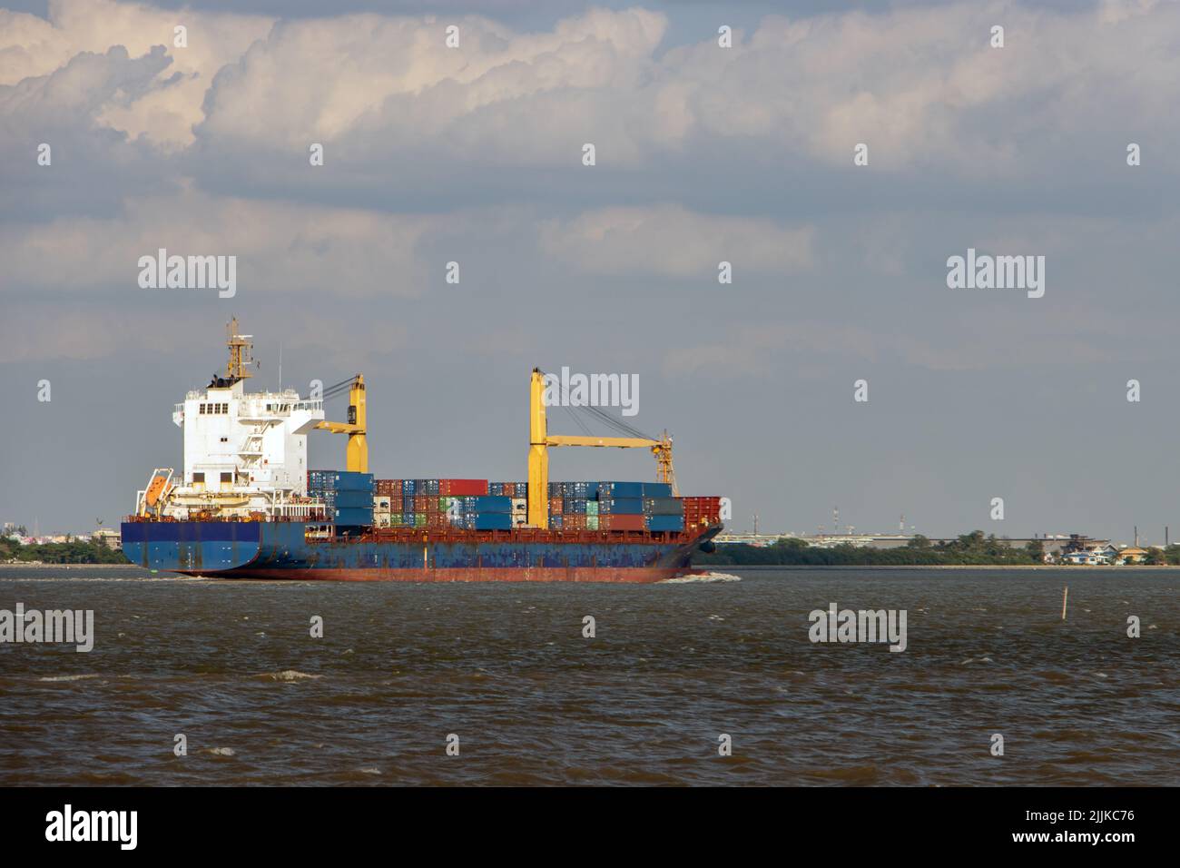 The Container Ship loaded of containers sails beside a seashore Stock ...