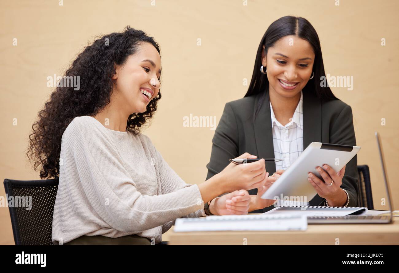 Our business plans are going great. two businesswoman using a digital ...