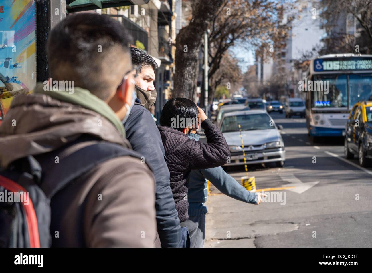Back people waiting for the bus that is arriving Stock Photo - Alamy