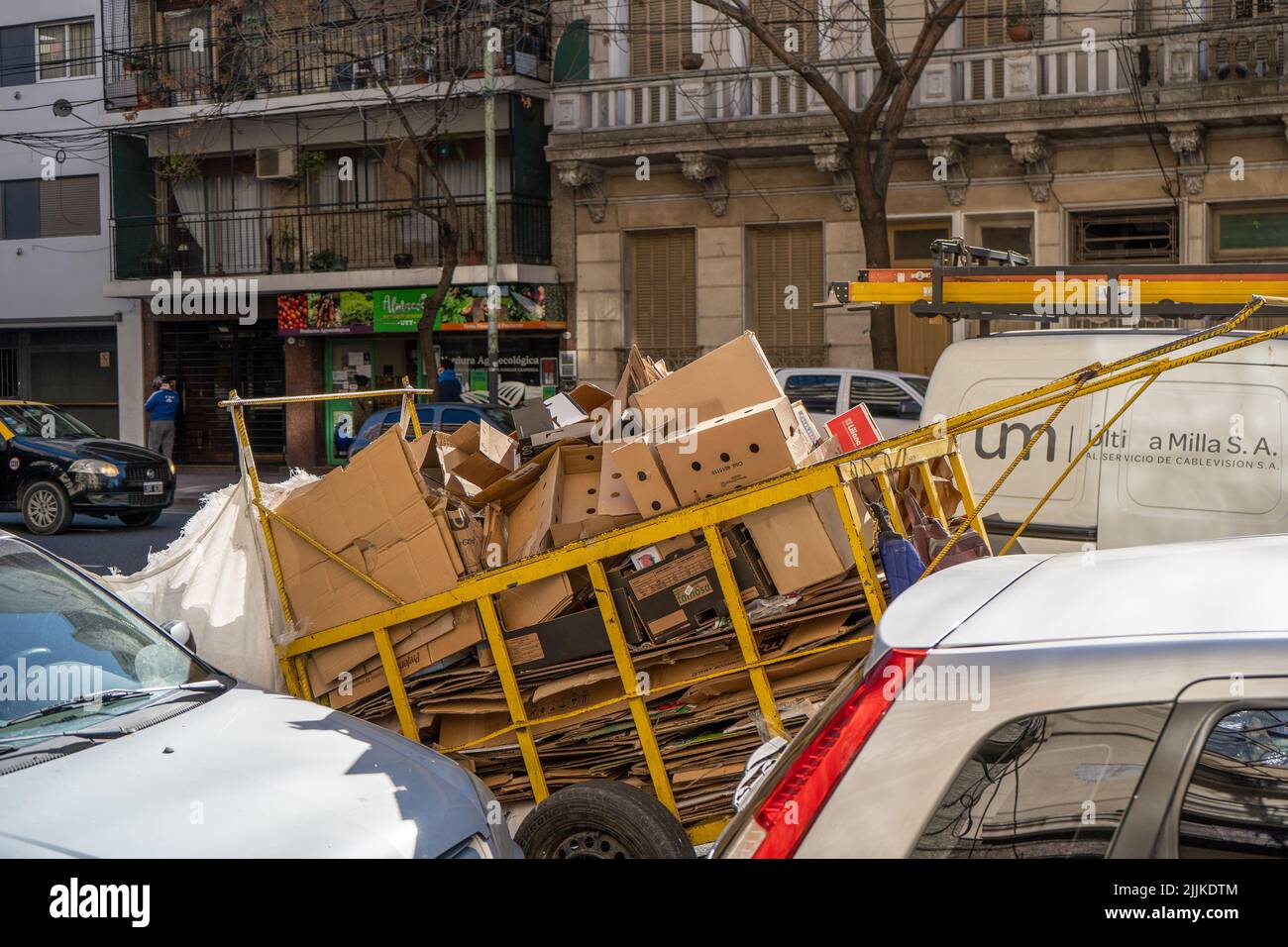Front shot of a cart with cardboard on the street, stopped between two ...