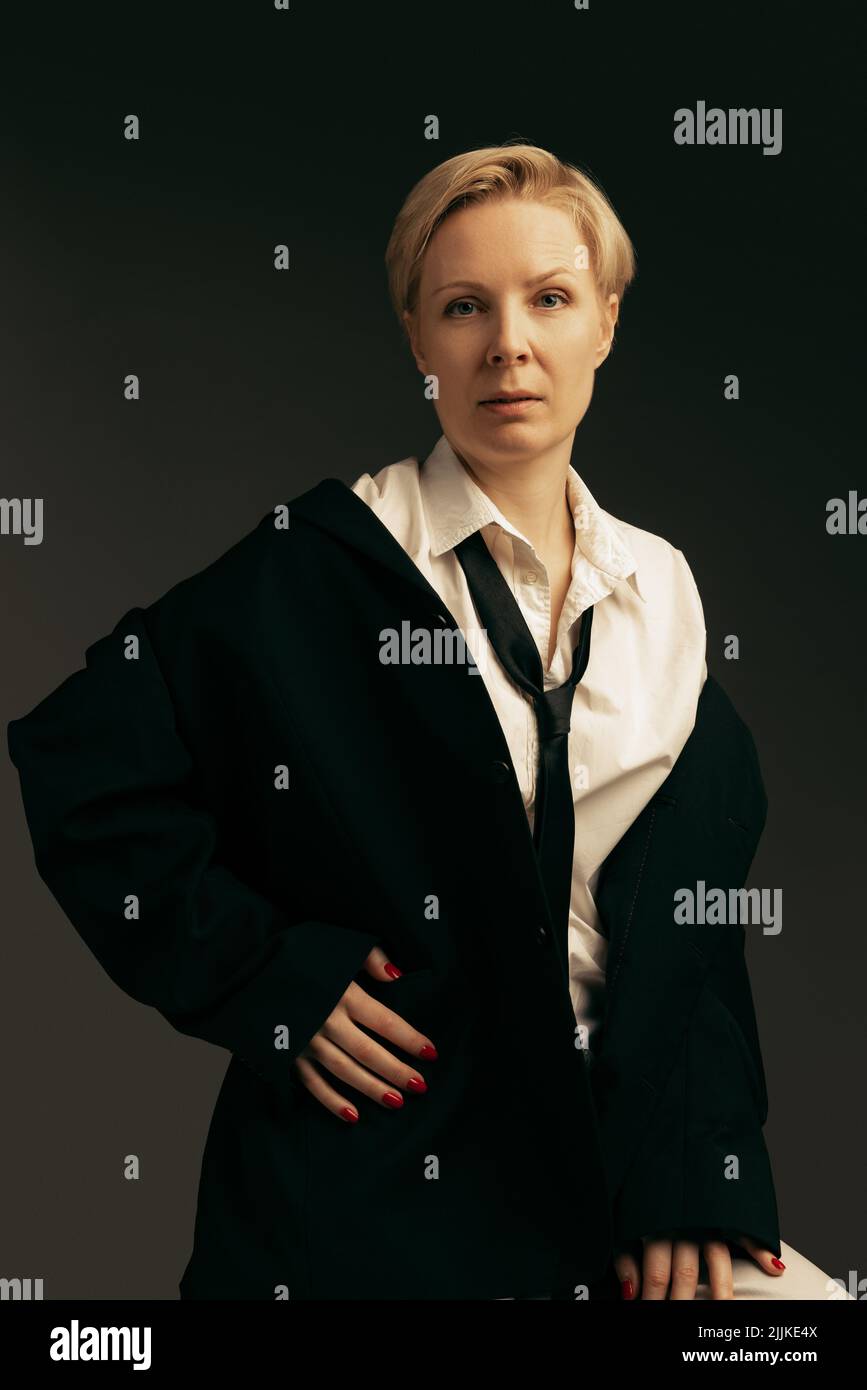 Portrait of beautiful middle-aged woman in stylish black suit posing ...