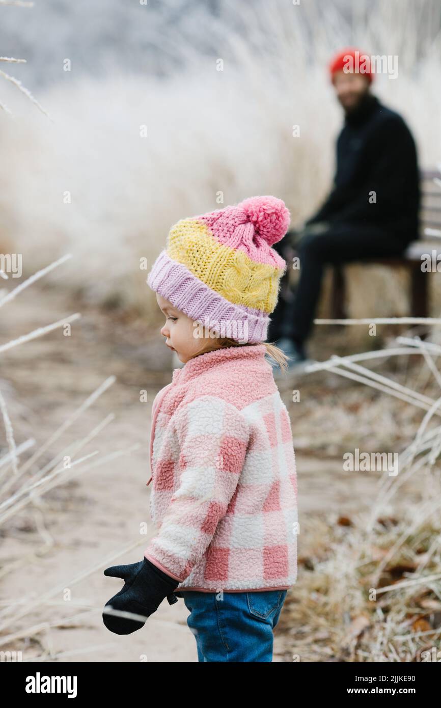 A closeup of a cute little girl walking on a trail and exploring nature ...