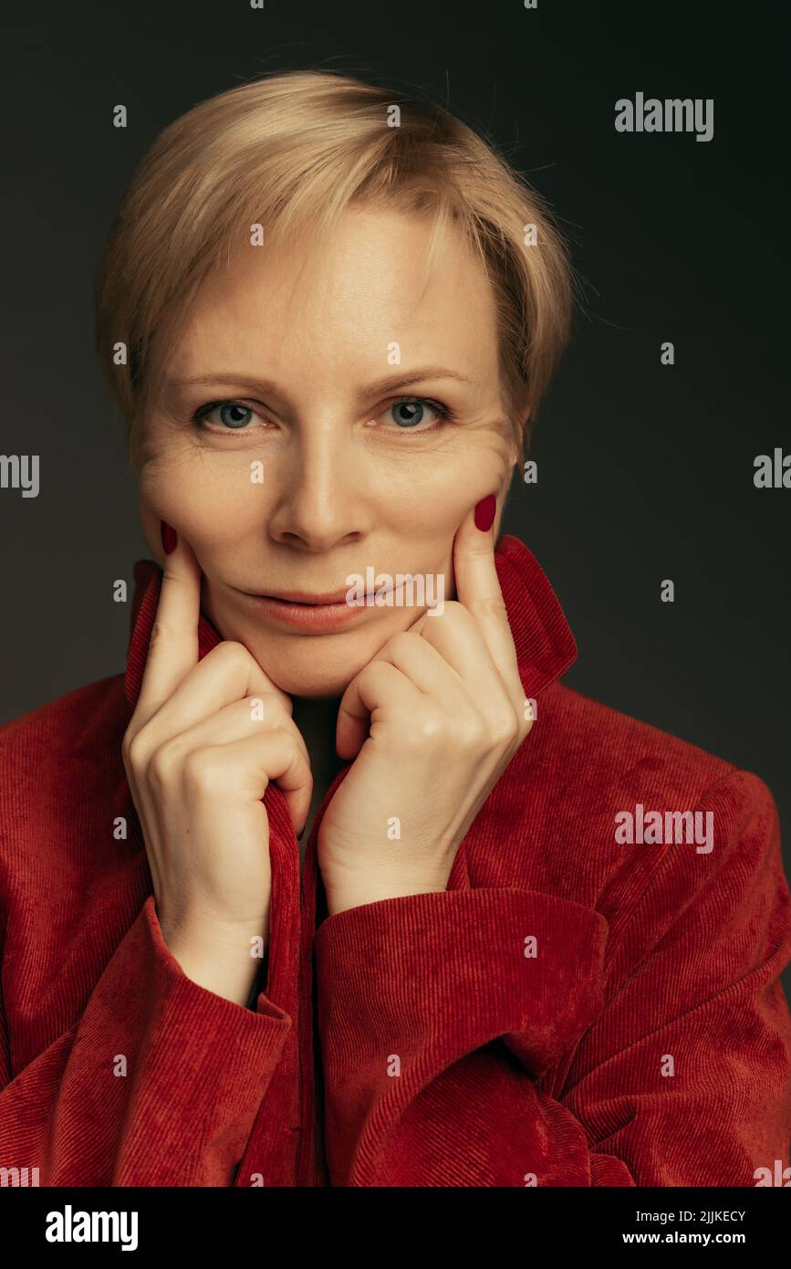 Portrait of beautiful middle-aged woman in stylish red velvet jacket ...