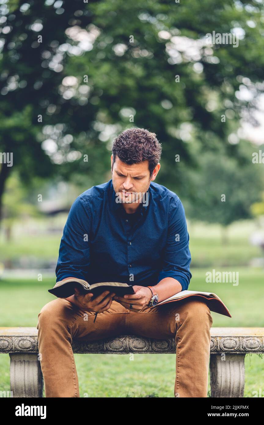 Man sitting bench reading book hi-res stock photography and images - Alamy