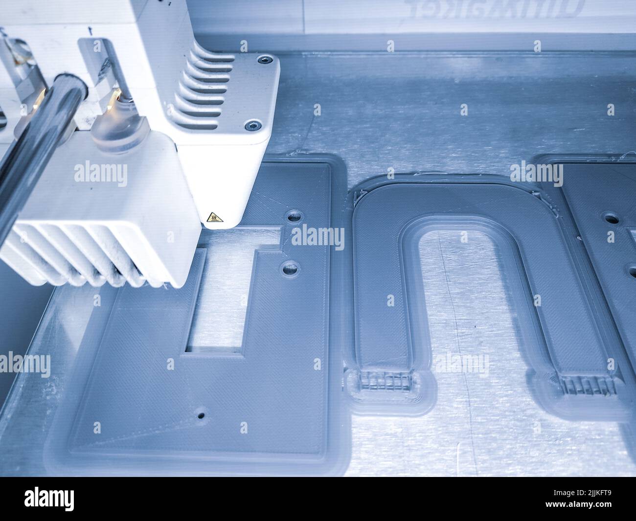 A closeup of a 3D printer with plastic wire filament in additive ...