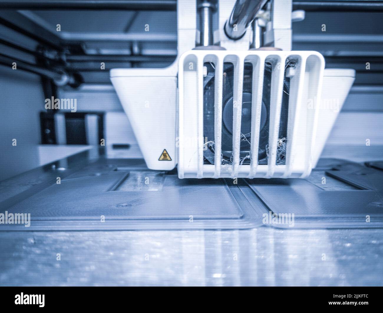 A closeup of a 3D printer with plastic wire filament in additive ...