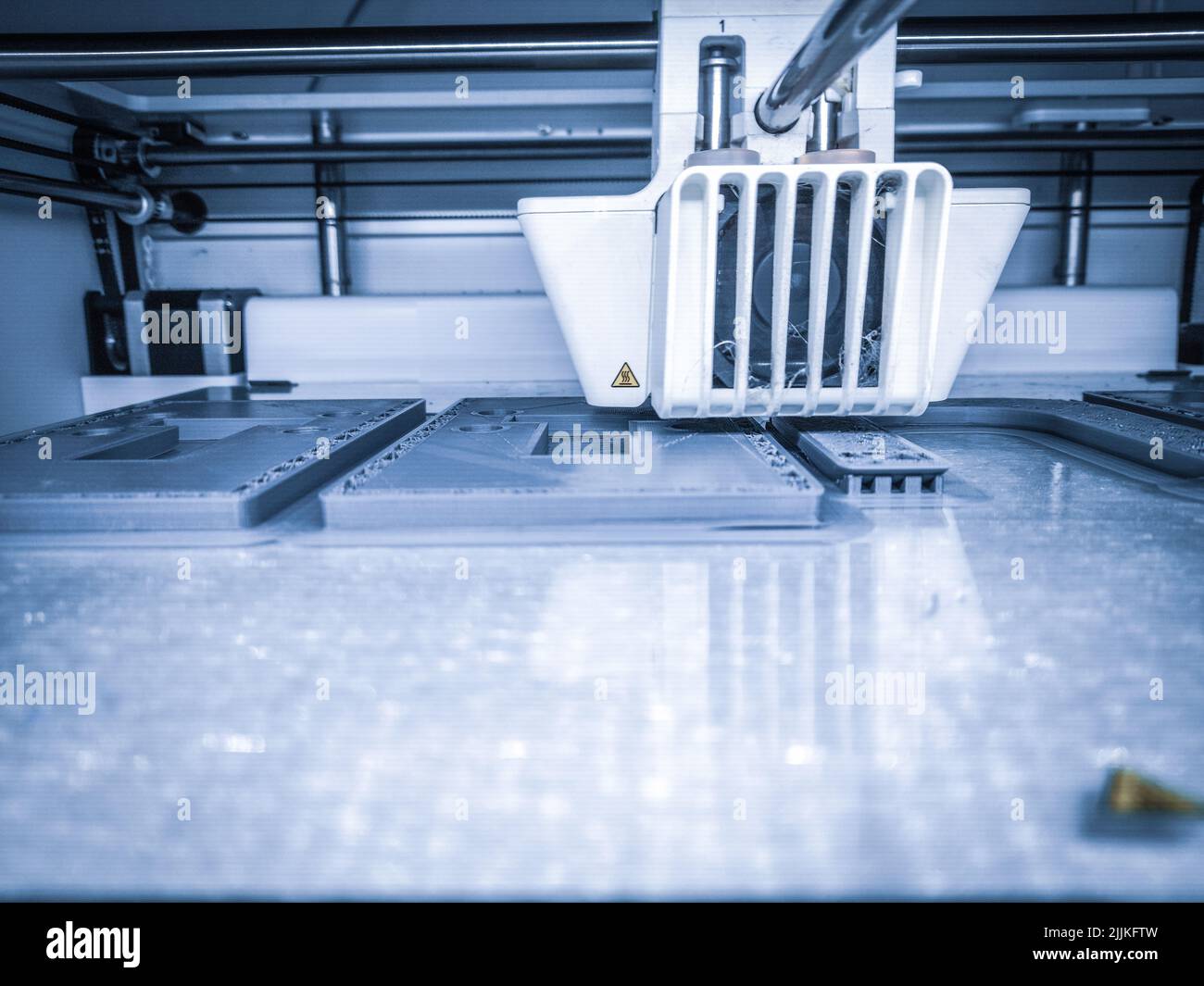 A closeup of a 3D printer with plastic wire filament in additive ...