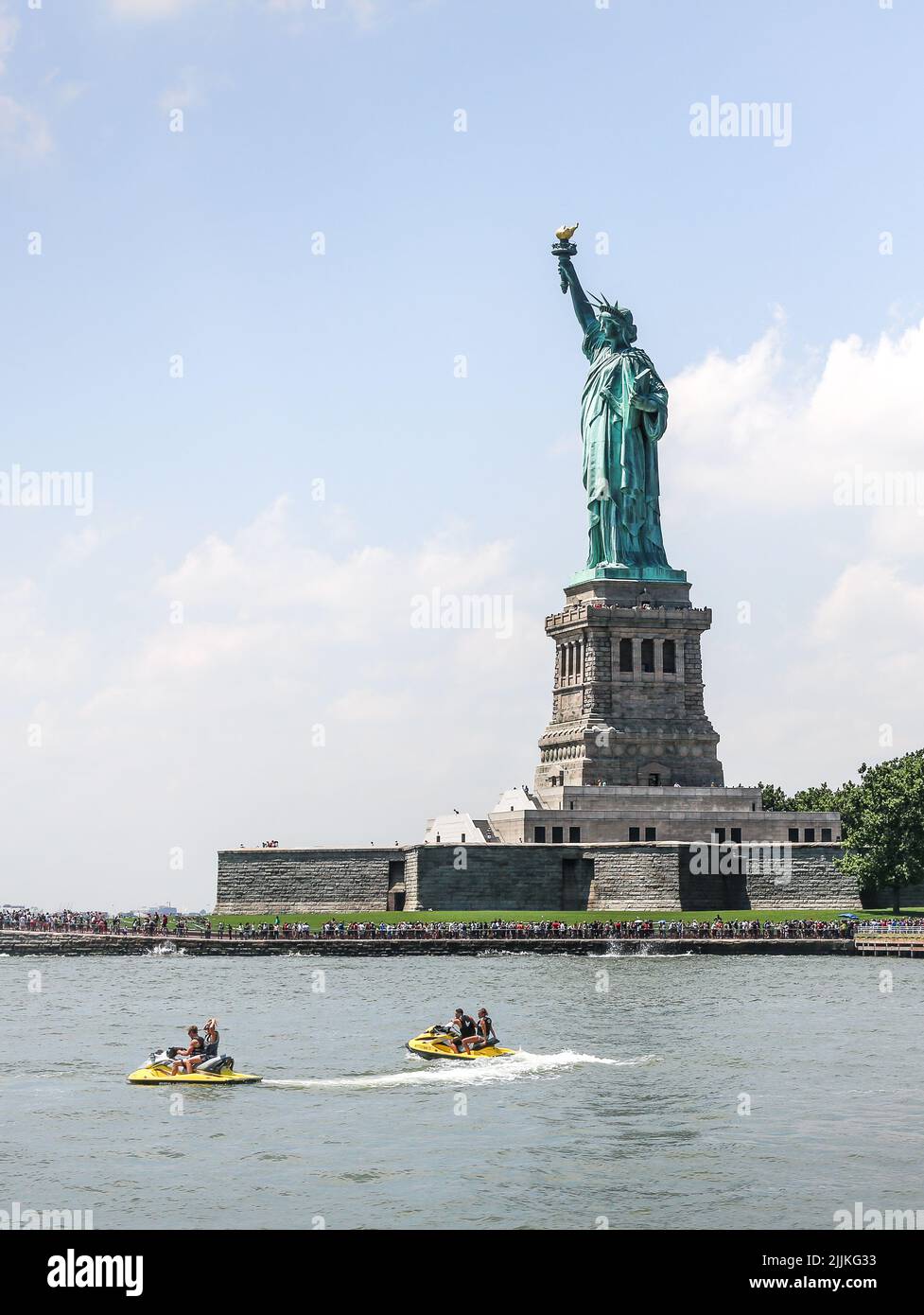 A vertical shot of jet skis in front of the statue of liberty, NYC ...