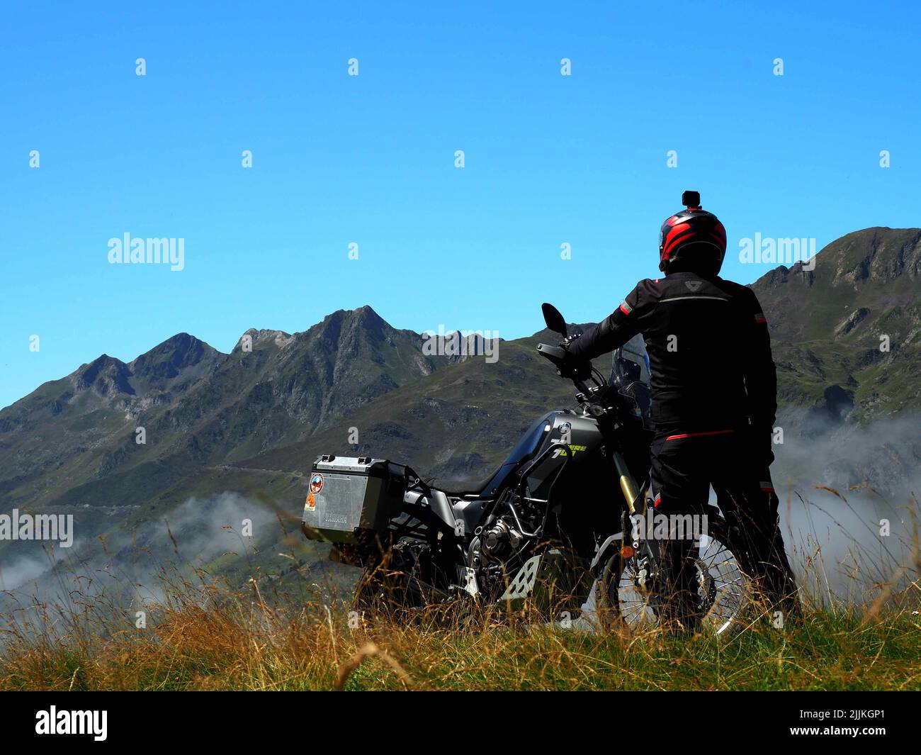 A motorcycle traveler enjoying the view of Col Du Tourmalet of the ...