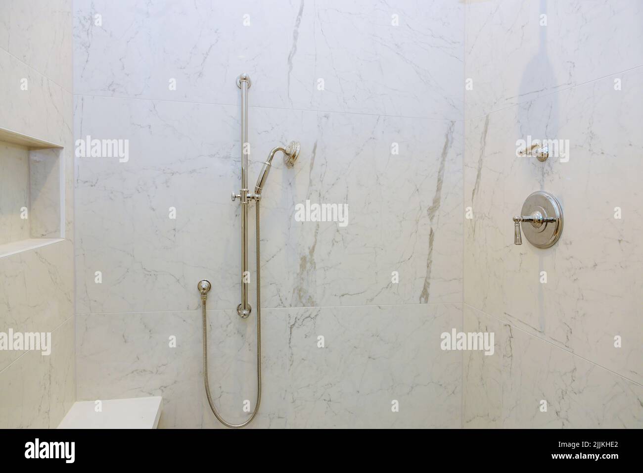 In the modern bathroom of a new construction, there is a shower head in ...