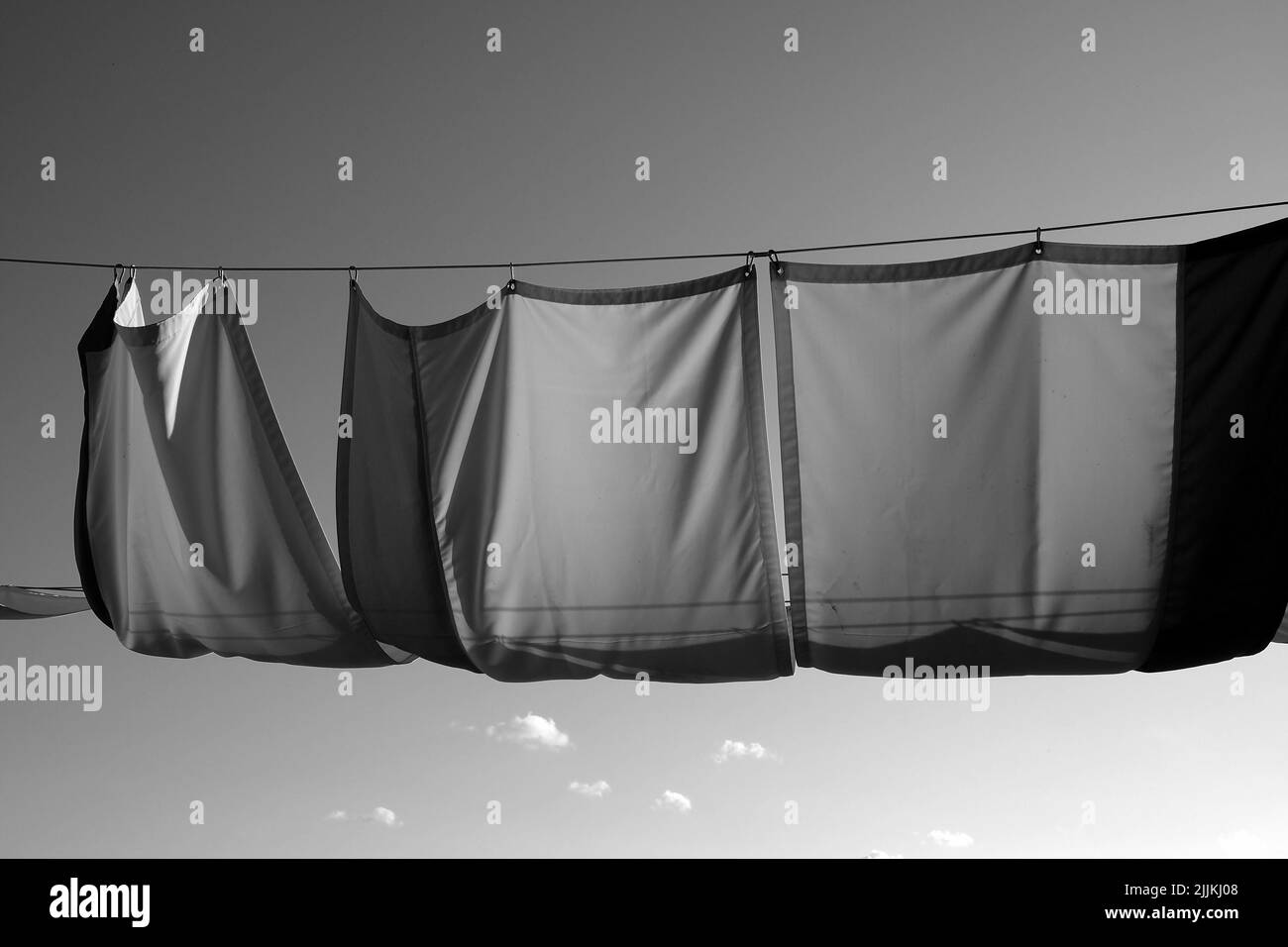 A greyscale shot of window curtain sheet hanging Stock Photo - Alamy