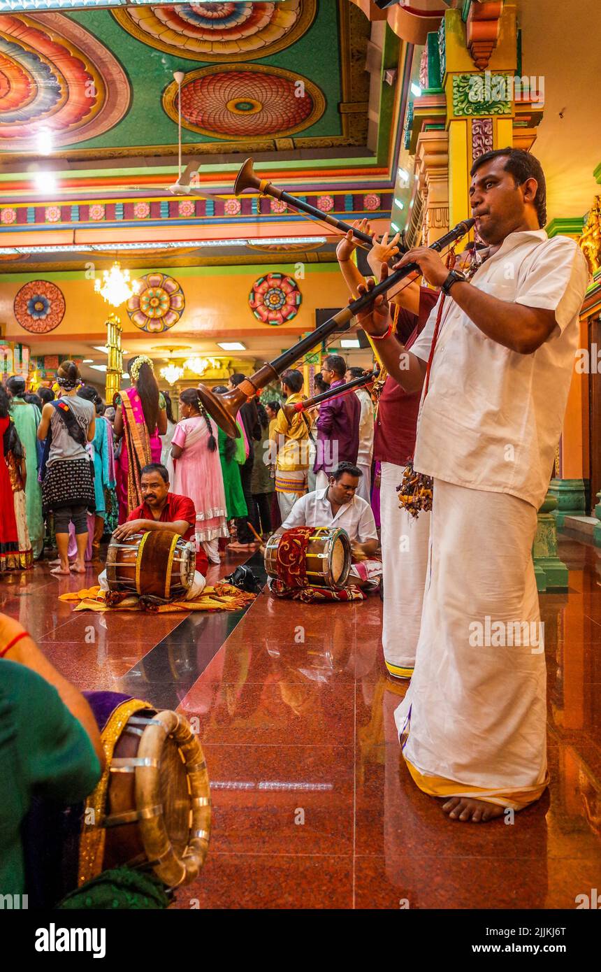 Hindu people playing different instruments in a temple during a ...