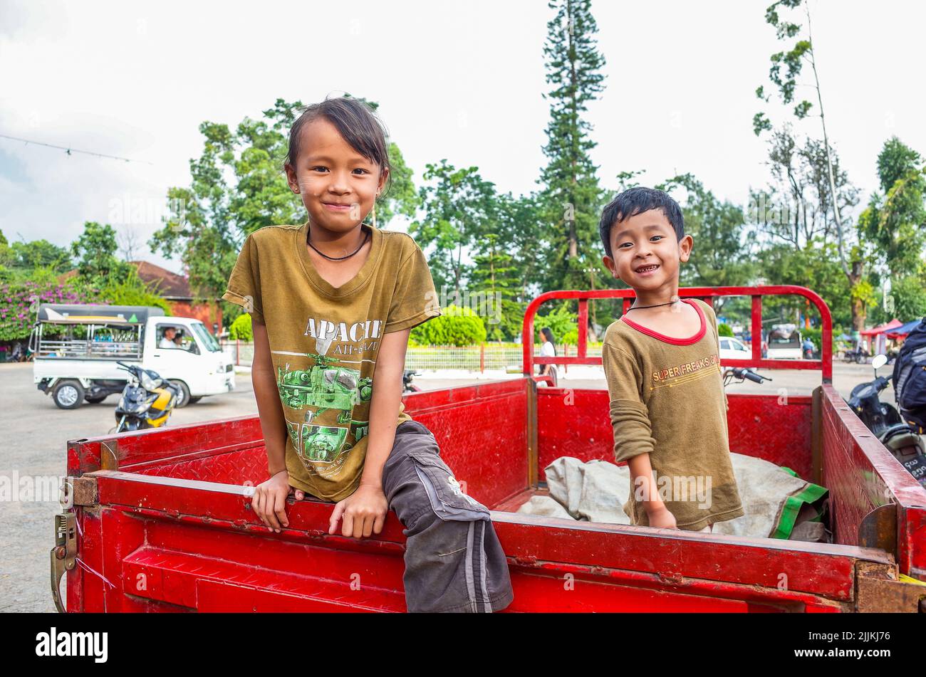 portrait photo of children in red car smiling and looking at the camera ...