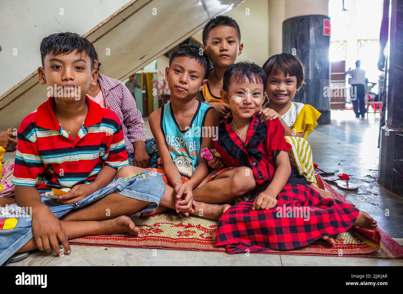 closeup photo of children sitting on the ground and looking at the ...