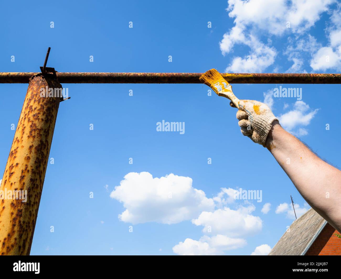 Brush paints rusty pipe yellow hi-res stock photography and images - Alamy