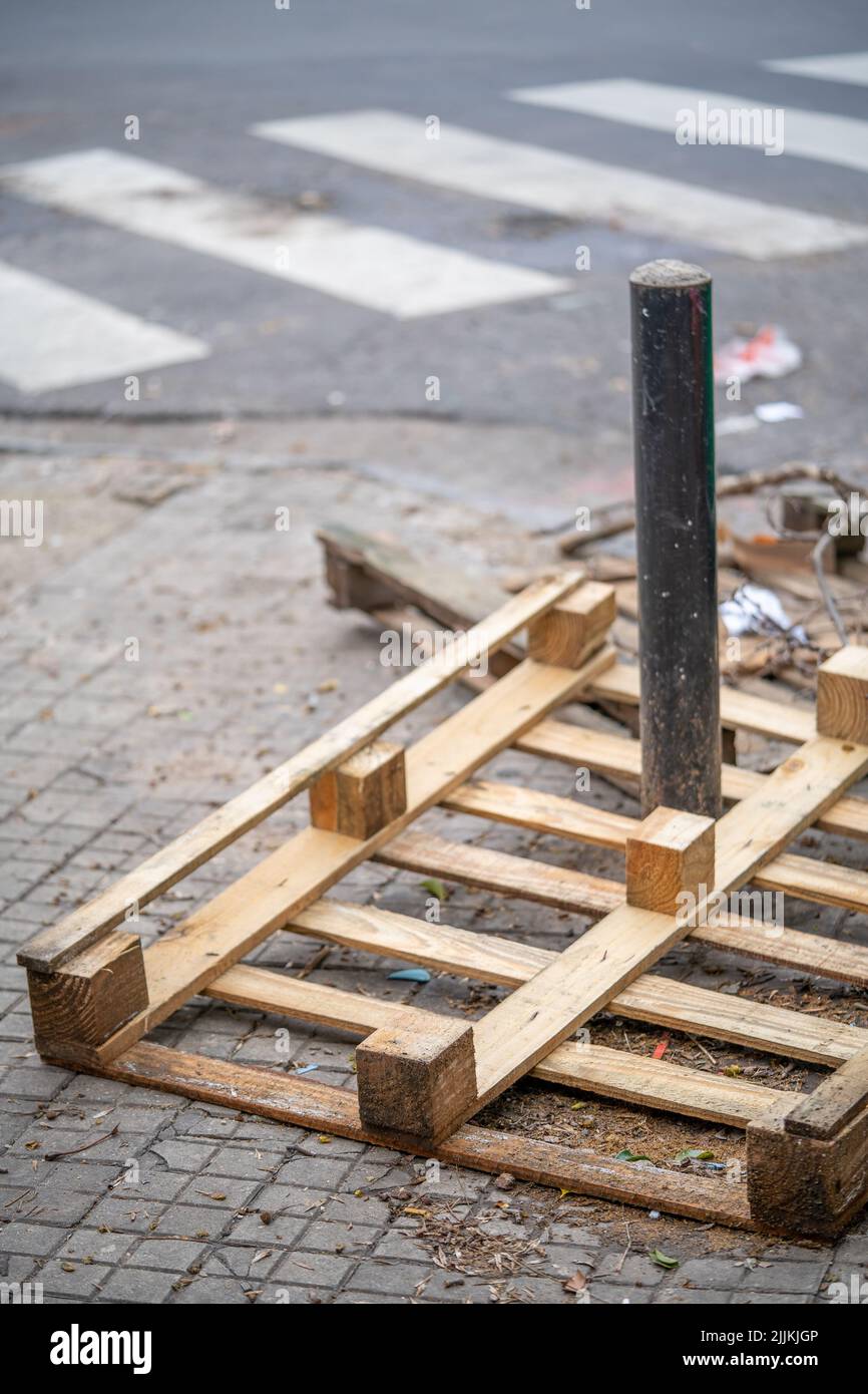 Selective focus of a wooden pallet on a column, dumped on the public ...