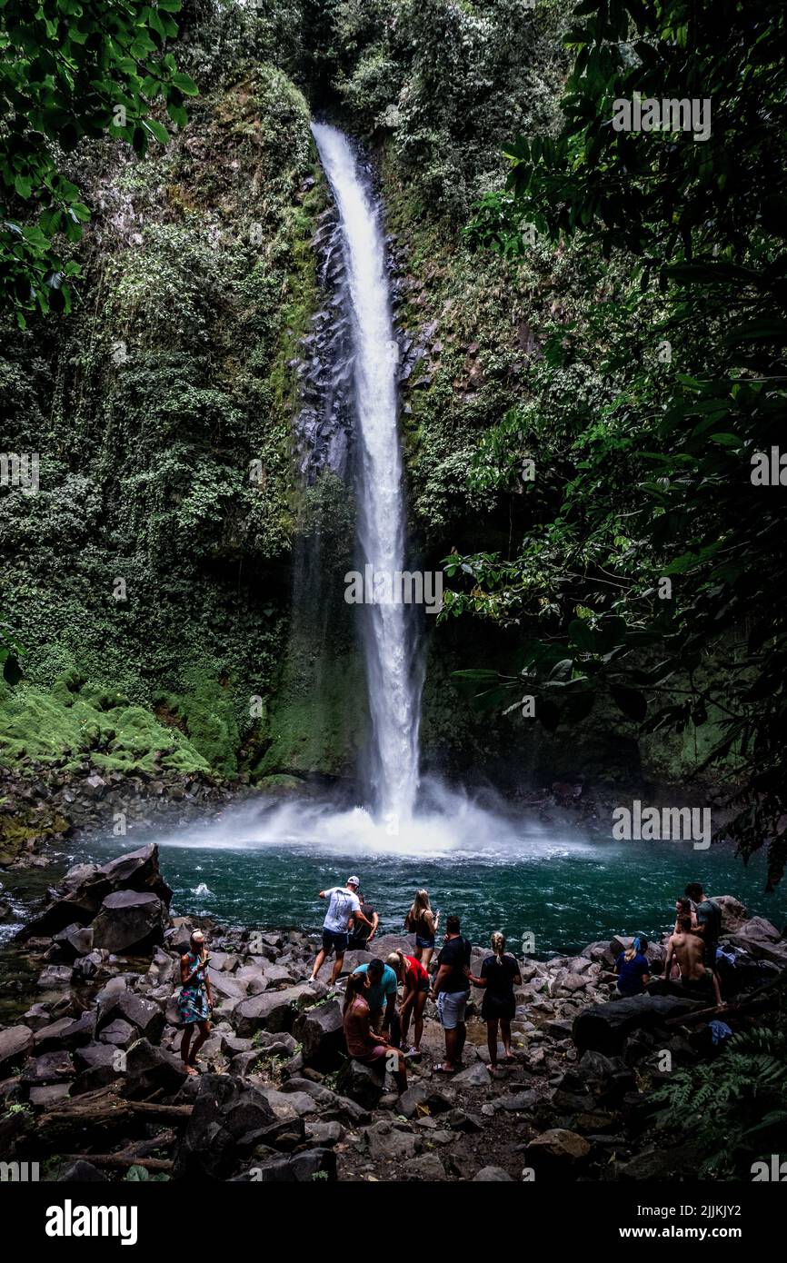 A vertical shot of people watching the waterfall in Puerto Viejo, Costa ...