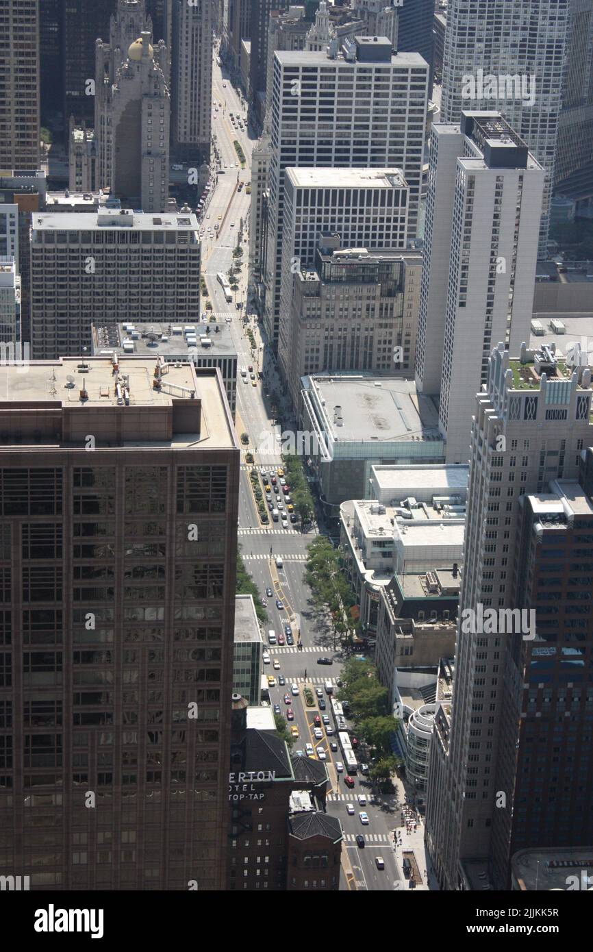 A vertical aerial view of cars on a road and downtown buildings in ...
