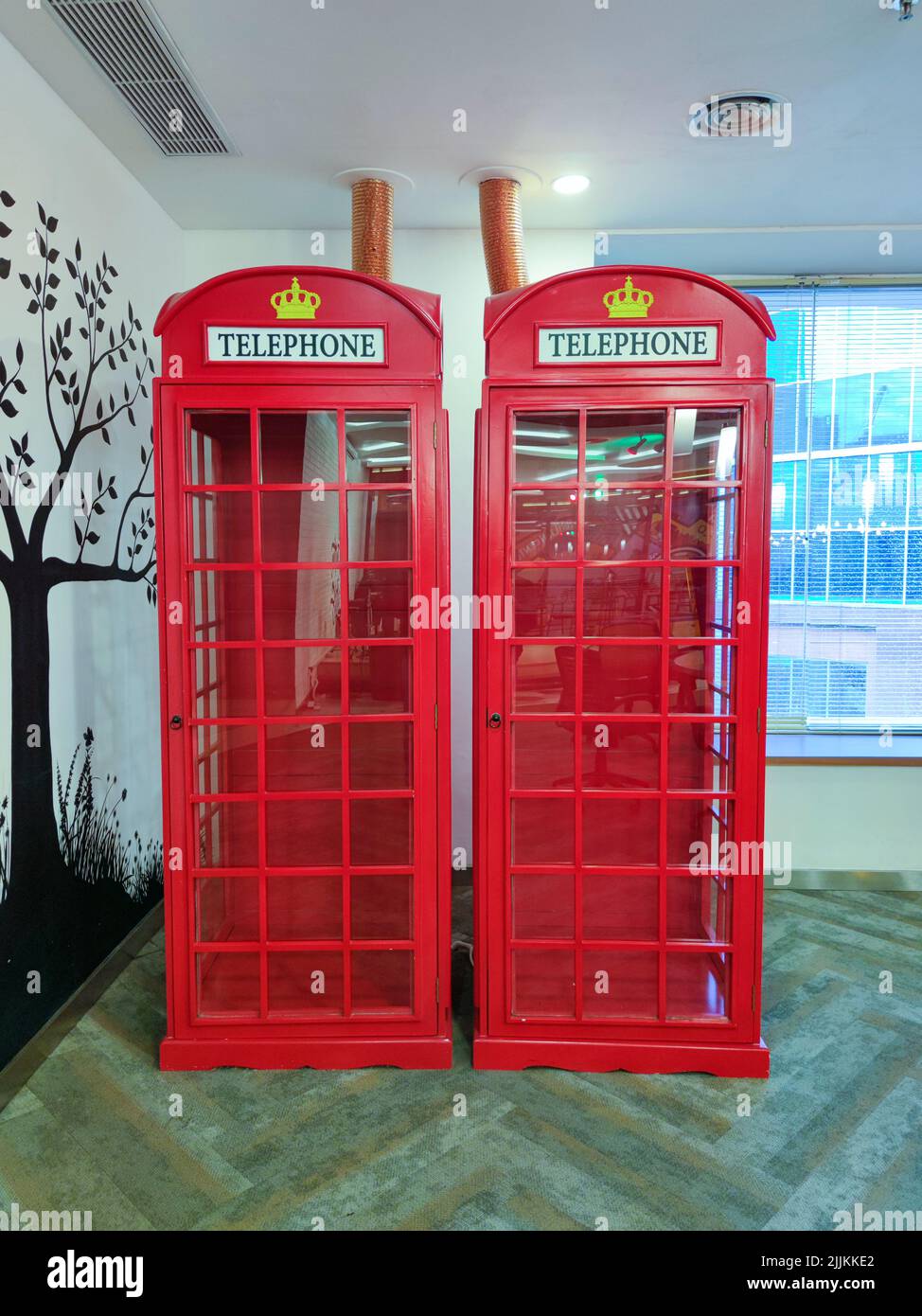 Red telephone booth replica with yellow queen crown logo inside room as ...