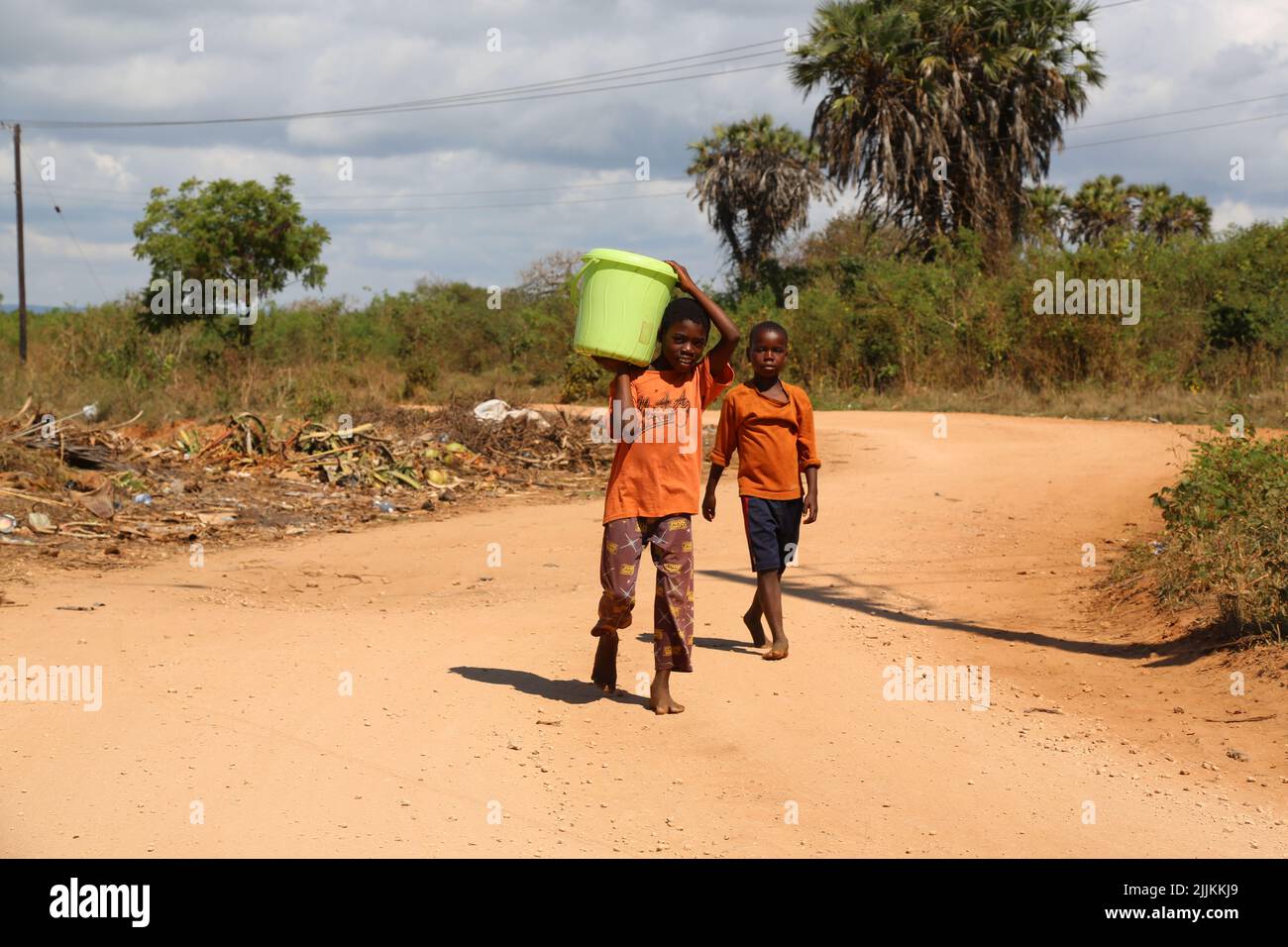 The local kids carrying water with buckets in Ukunda, Kenya Stock Photo ...