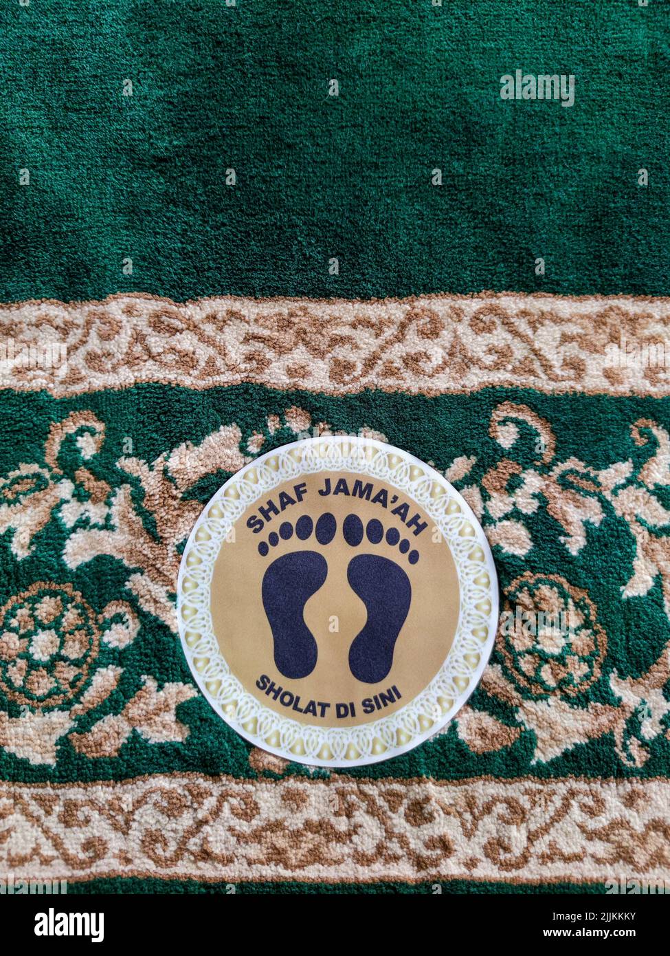 Close up of sign on green carpet for prayer spot with flower pattern in ...