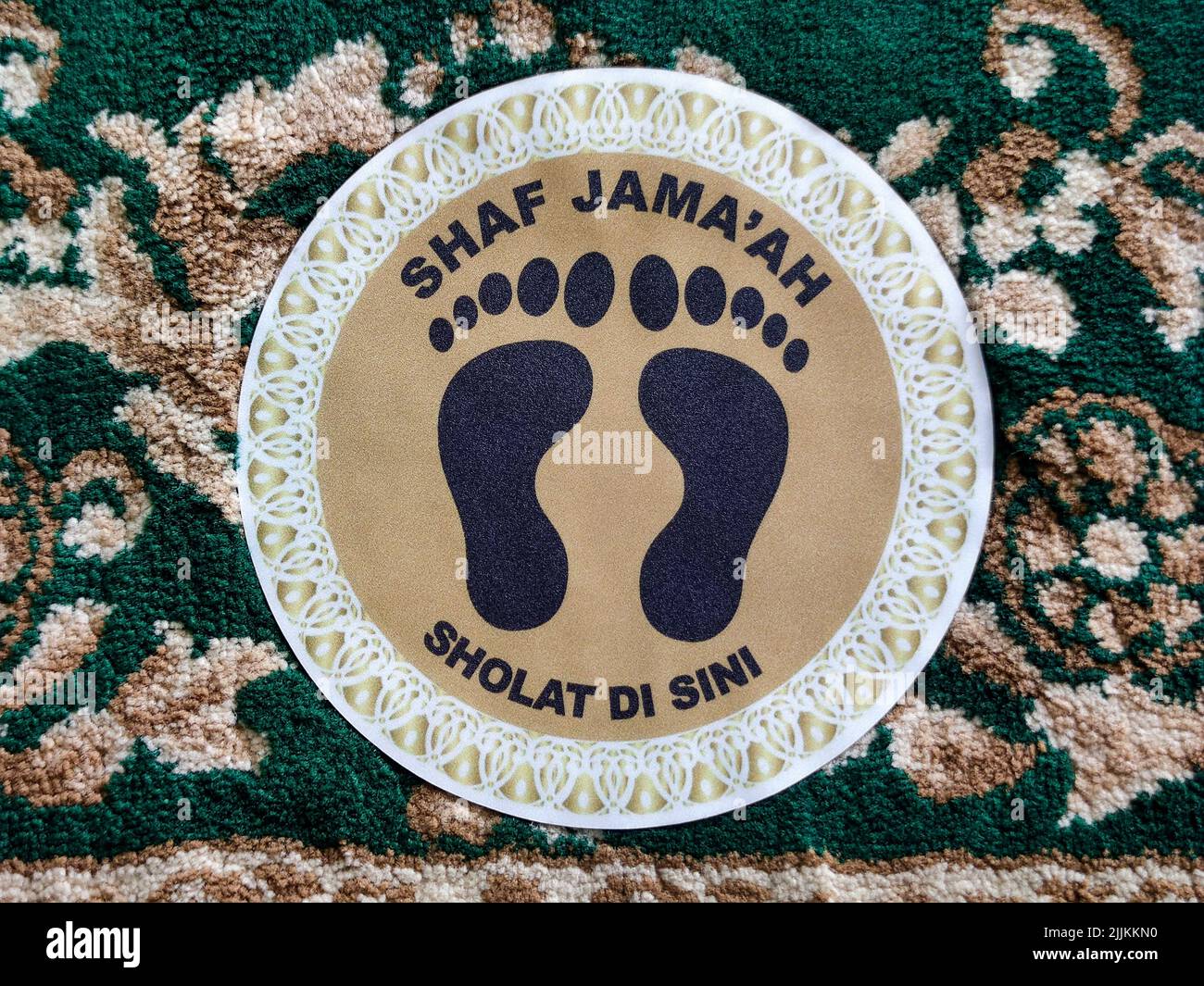 Close up of sign on green carpet for prayer spot with flower pattern in ...