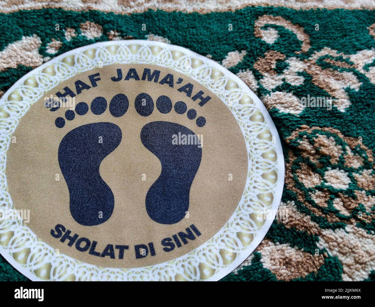 Close up of sign on green carpet for prayer spot with flower pattern in ...