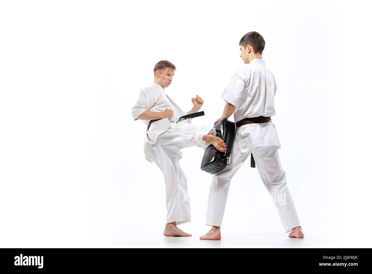 Two athletes, karate-do fighters in doboks practicing karate isolated ...