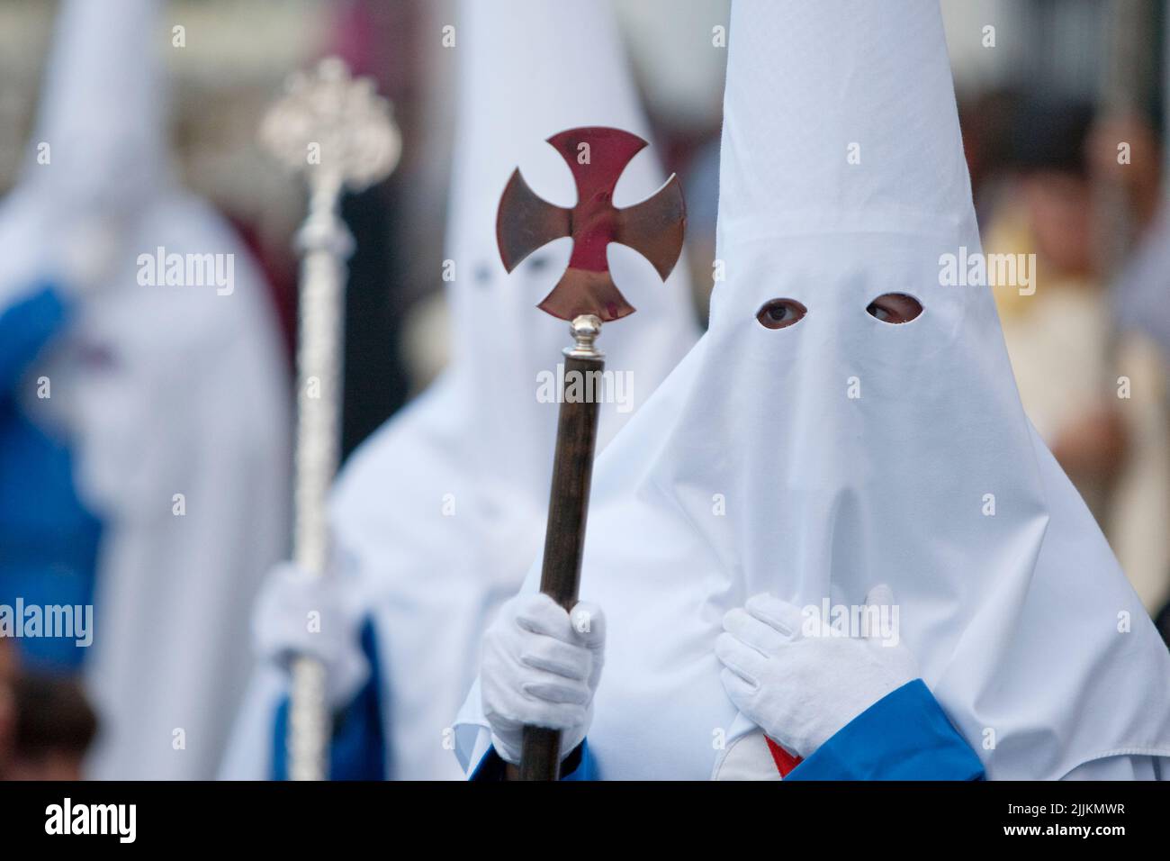 A portrait of a person with a traditional capirote and a cross at the ...