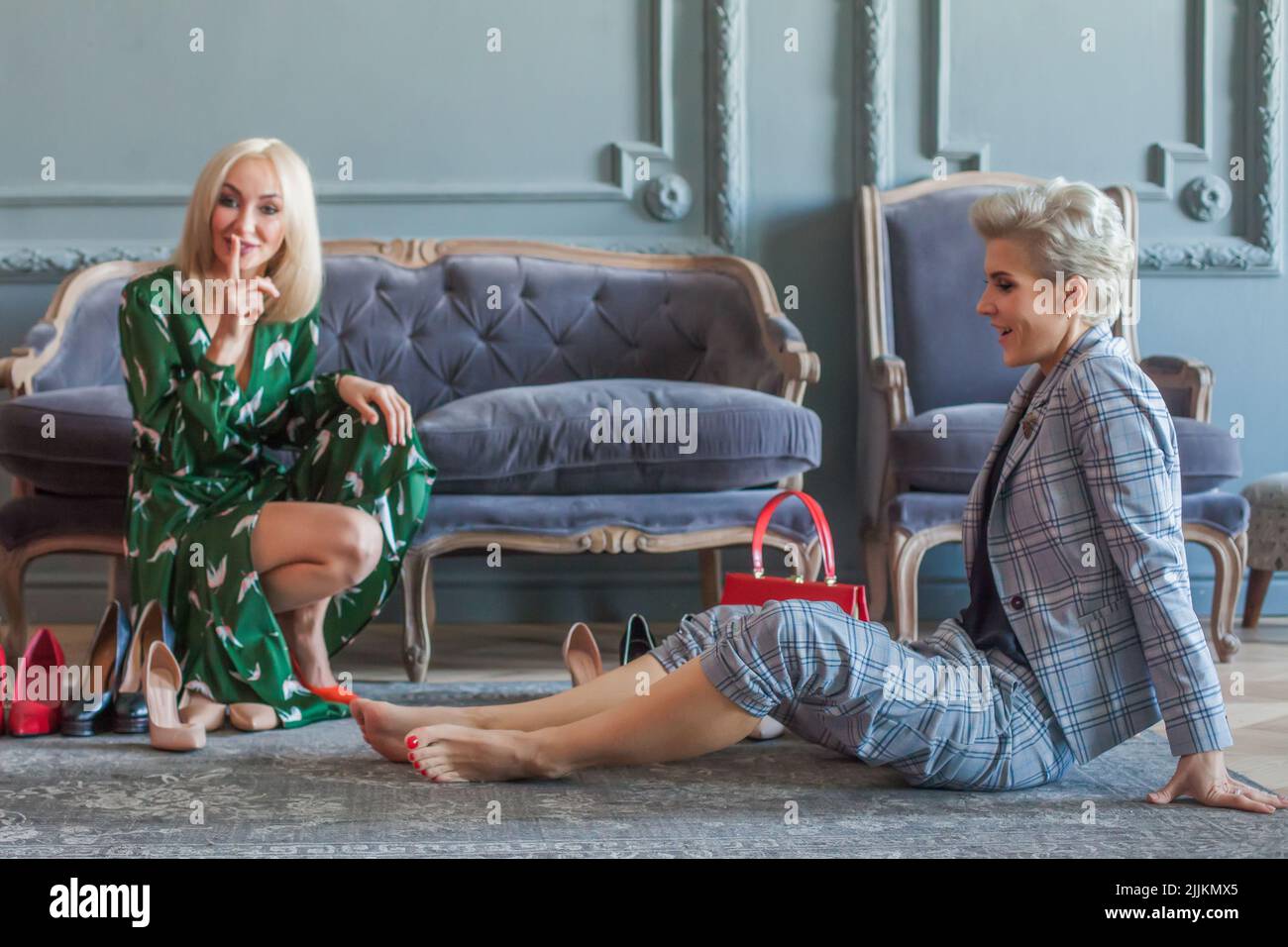 Professional stylist helping woman client to choose shoes Stock Photo ...