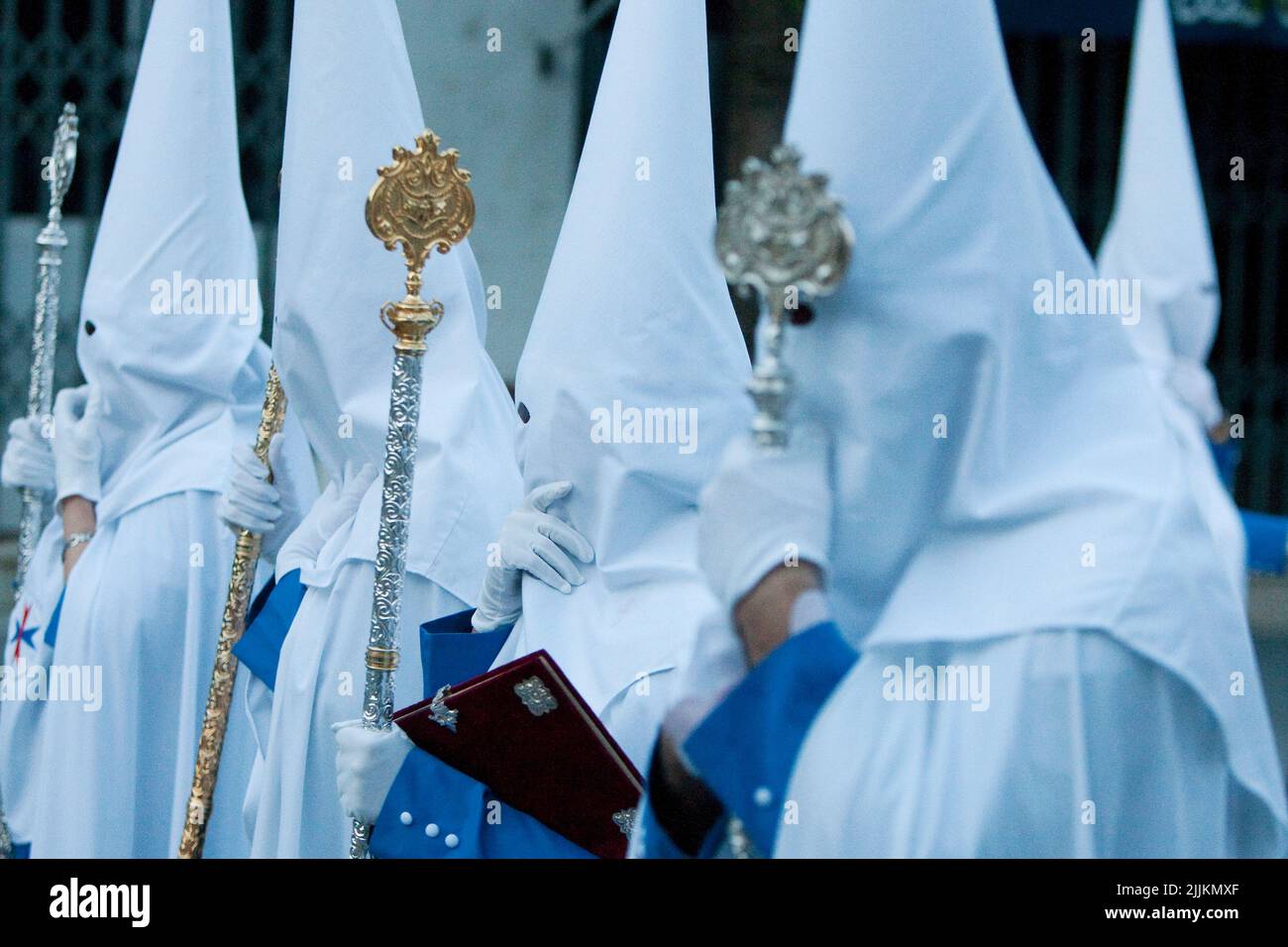 A group of people with traditional capirotes and scepters in the ...