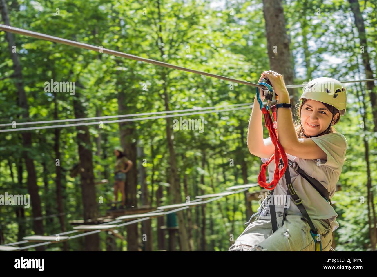 Happy women girl female gliding climbing in extreme road trolley ...
