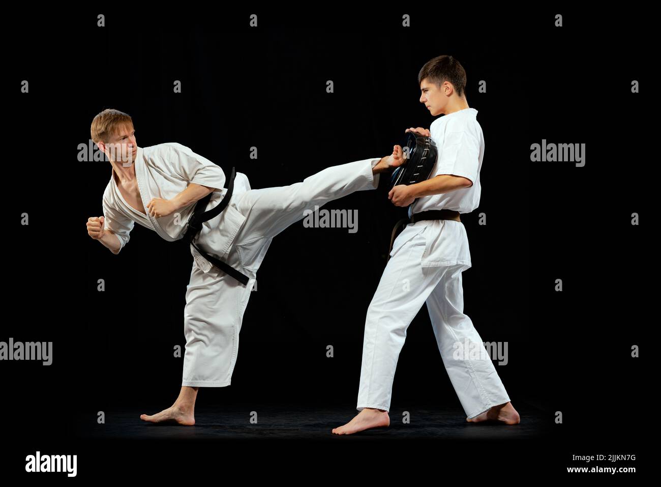 Dynamic portrait of male karate-do fighters in sports uniform training ...