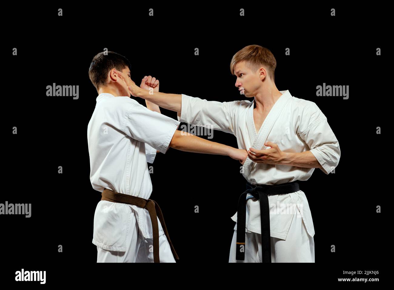 Dynamic portrait of male karate-do fighters in sports uniform training ...
